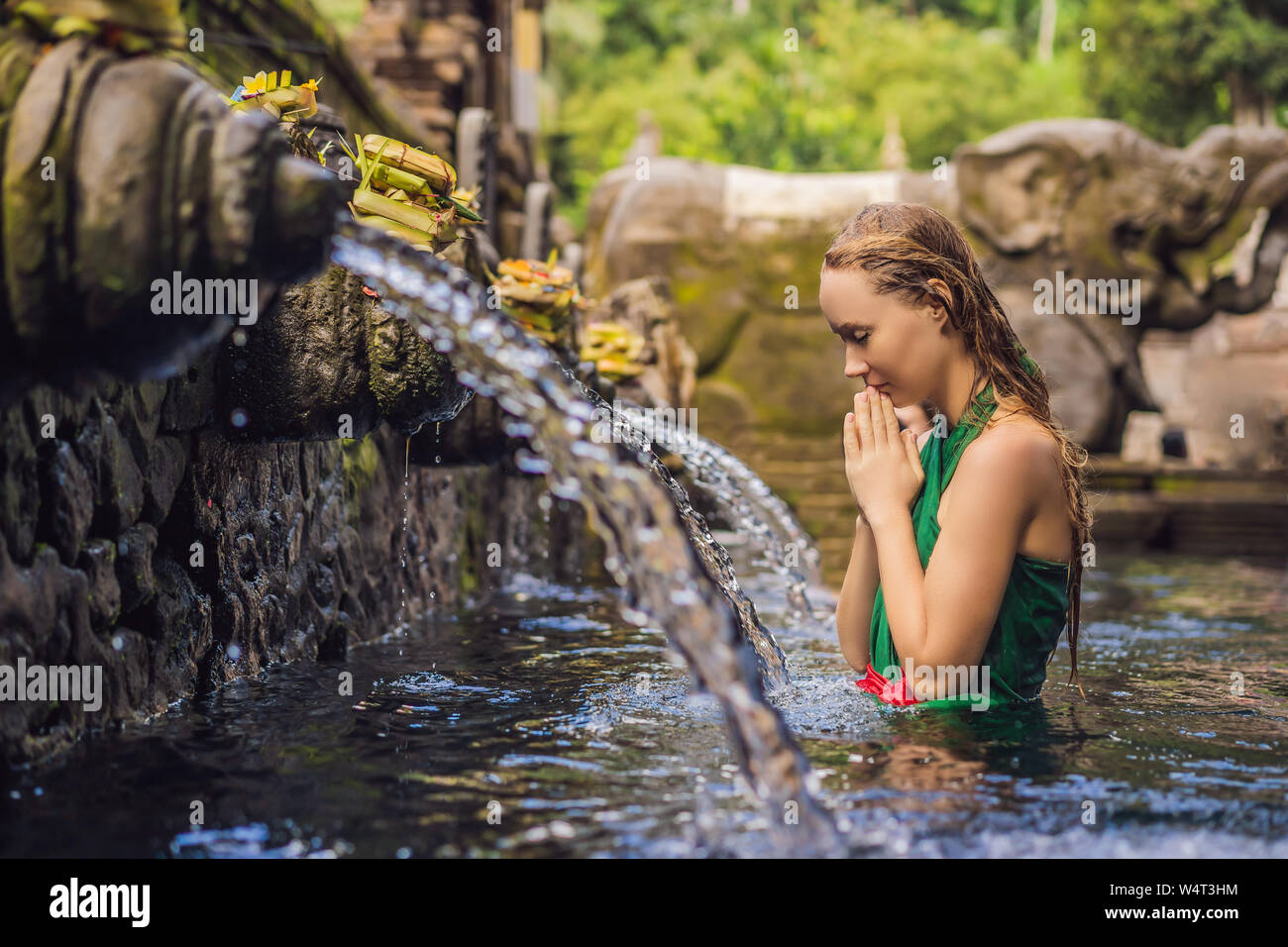 Woman in holy spring water temple in bali. The temple compound consists ...