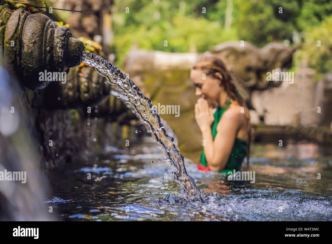 Woman in holy spring water temple in bali. The temple compound consists ...