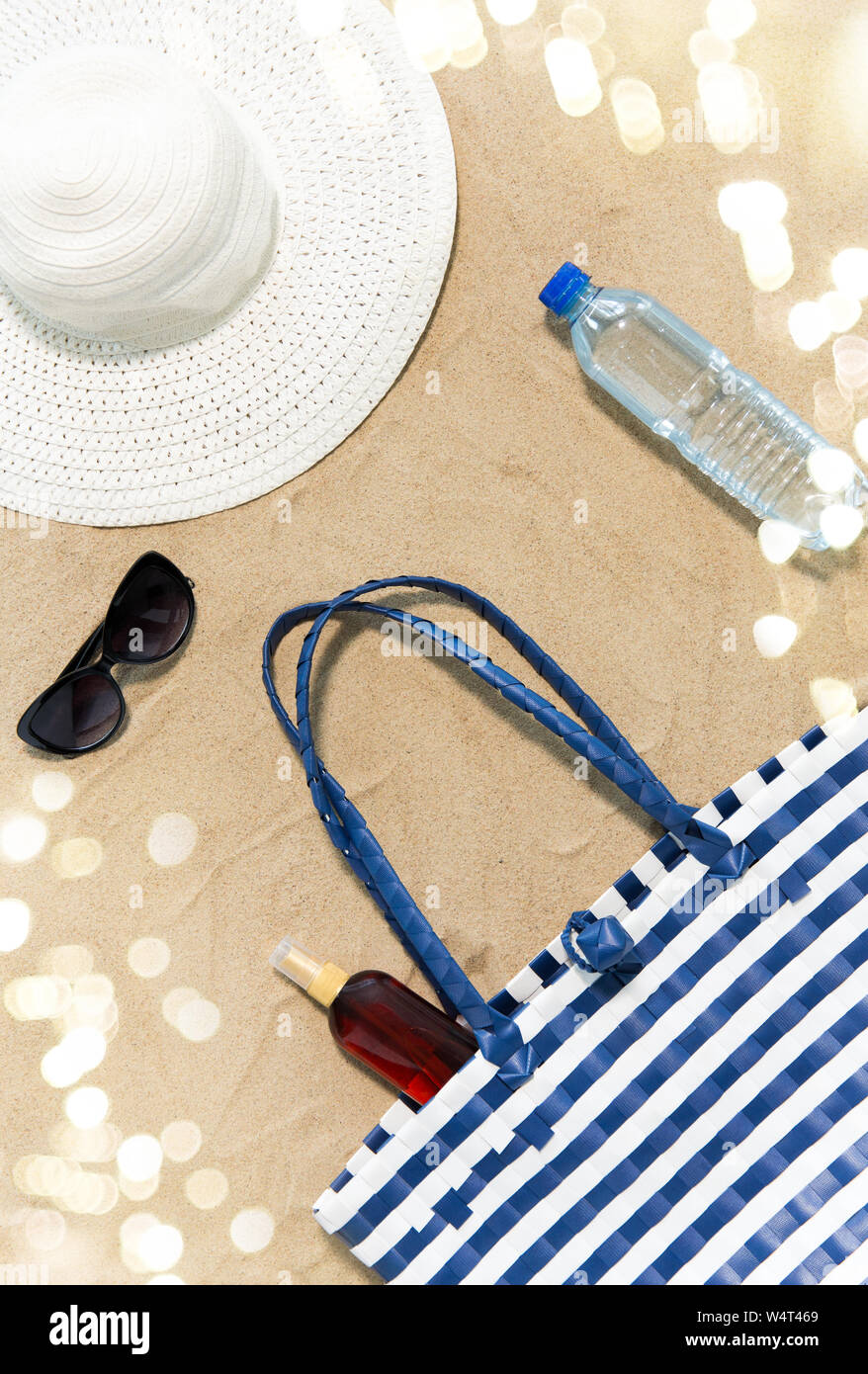 beach bag, sunscreen, sunglasses and hat on sand Stock Photo - Alamy