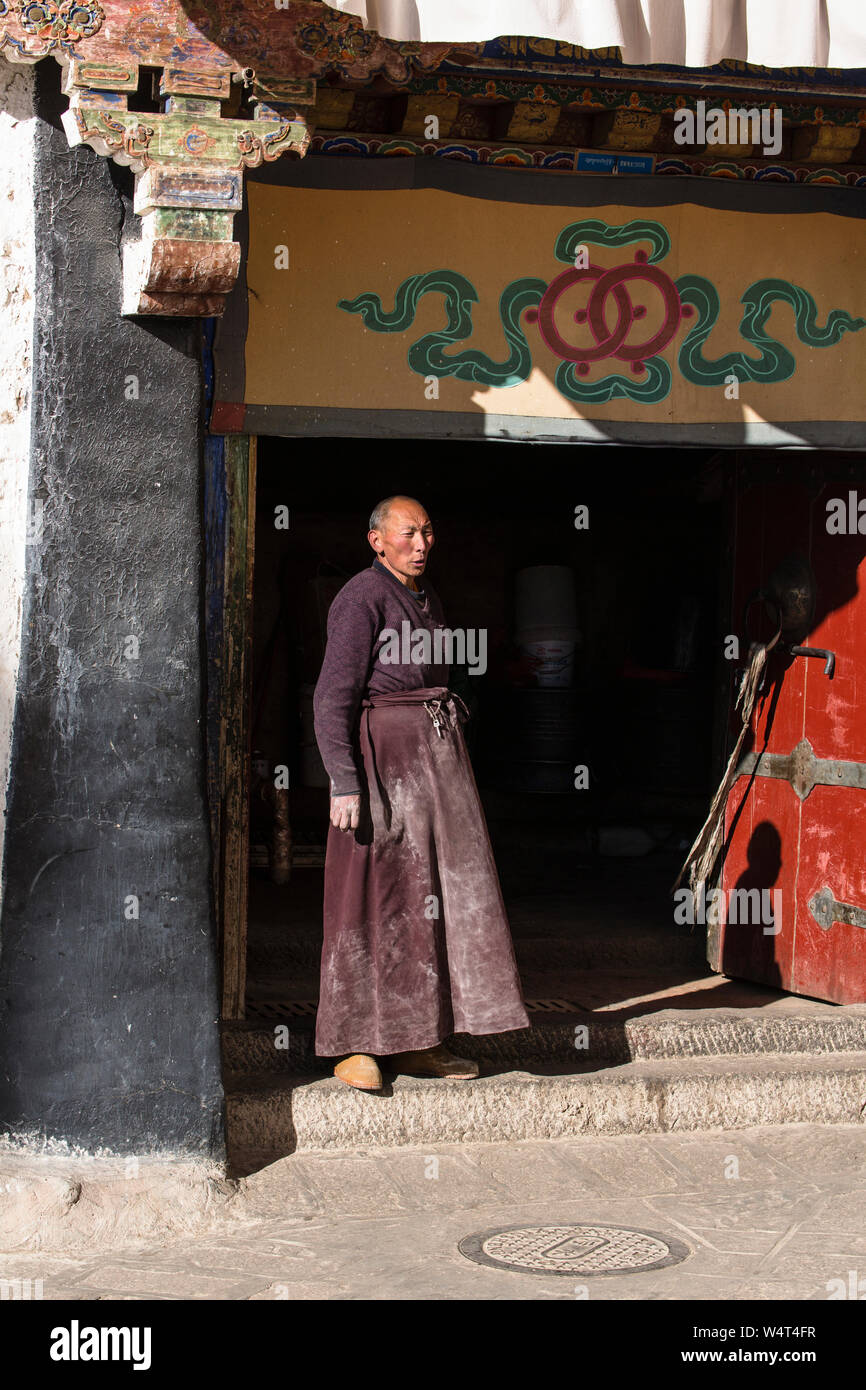 China, Tibet, Lhasa, A monk a cook standing in the doorway of the ...