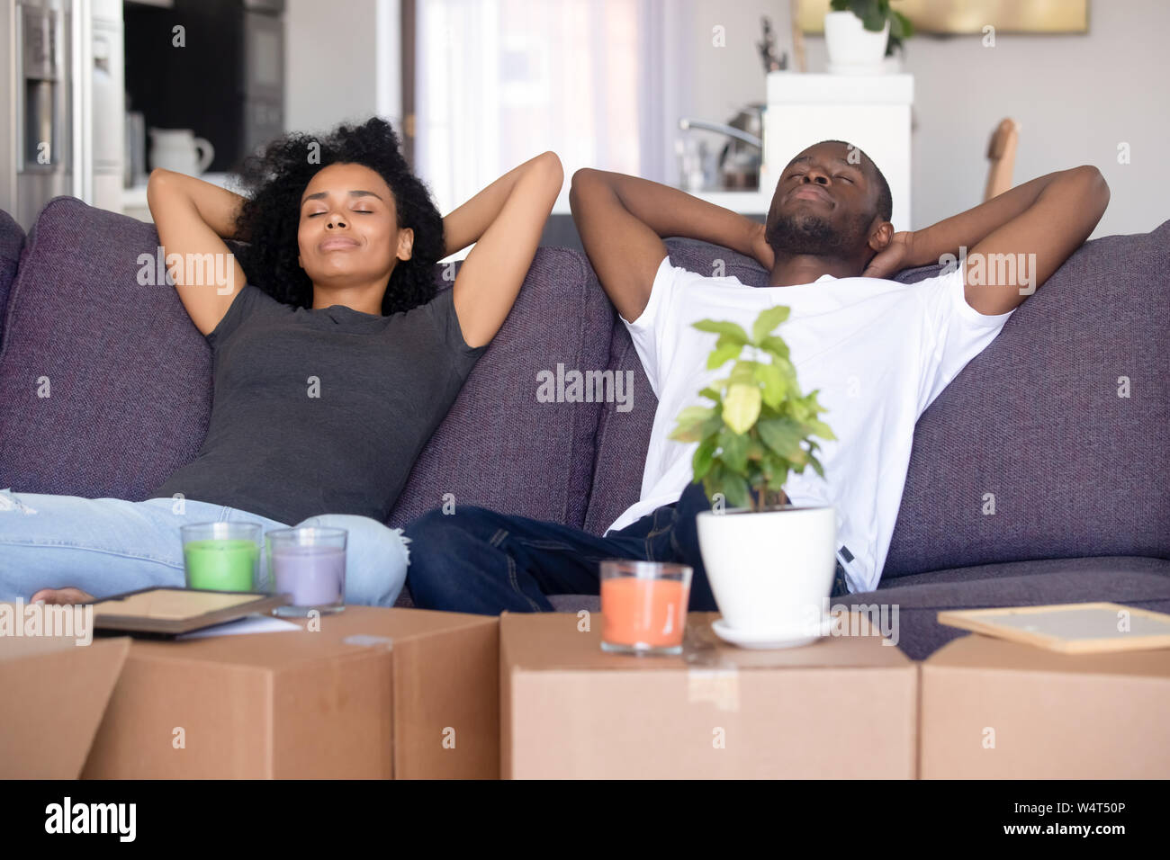 Tranquil african millennial couple resting on couch on moving day Stock ...