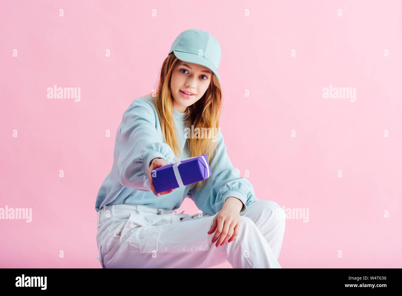 pretty teenage girl in cap isolated on pink Stock Photo - Alamy