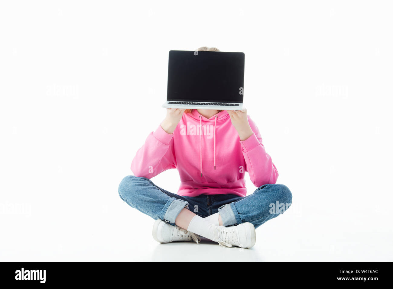 teenage girl with obscure face and crossed legs holding laptop with ...