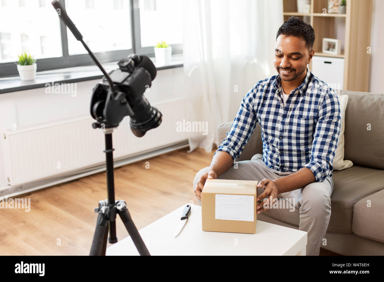 male video blogger opening parcel box at home Stock Photo - Alamy