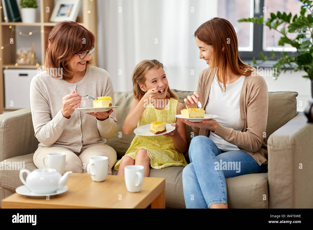 mother, daughter and grandmother eating cake Stock Photo - Alamy