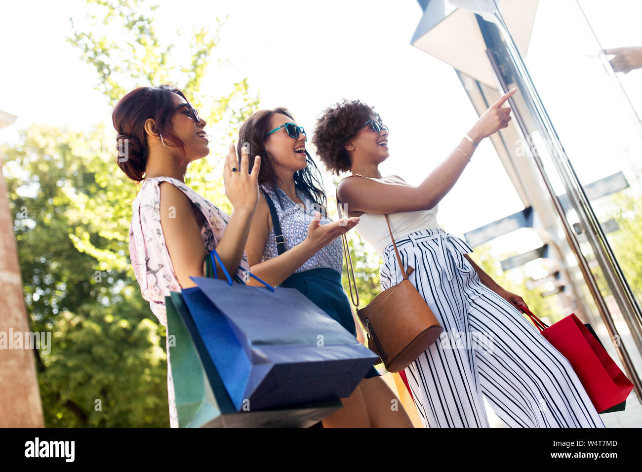 women with shopping bags looking at shop window Stock Photo - Alamy