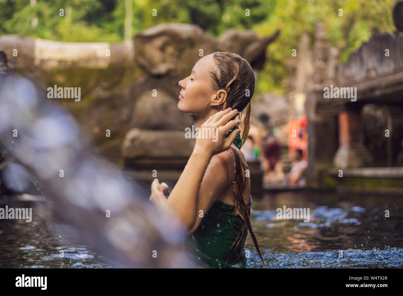 Woman in holy spring water temple in bali. The temple compound consists ...