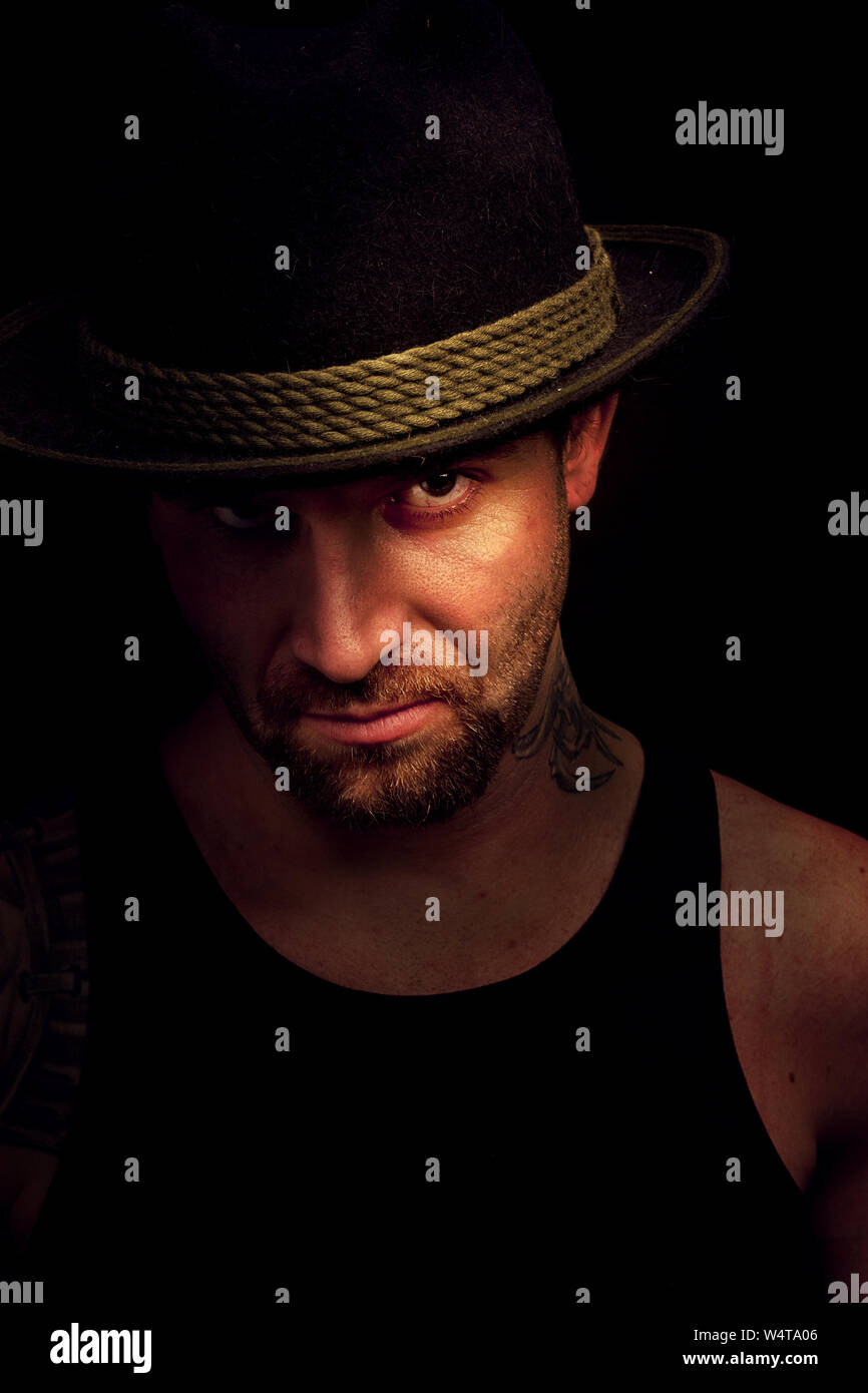 low key portrait of young gangster with hat in the darkness Stock Photo ...