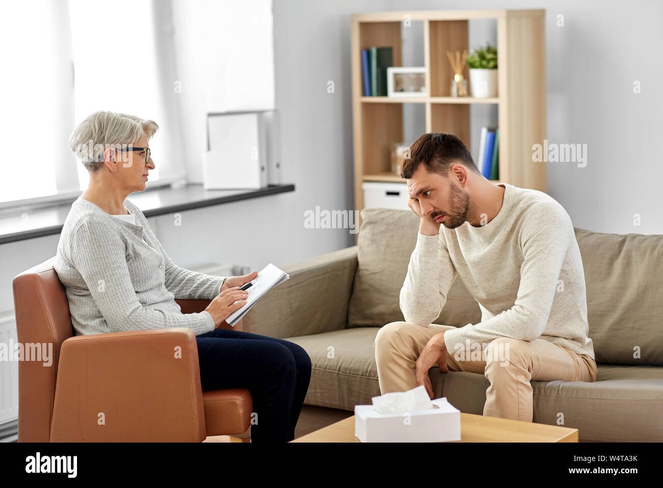 senior woman psychologist and sad man patient Stock Photo - Alamy