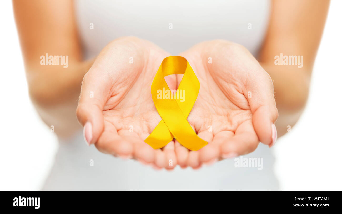 hands holding yellow gold cancer awareness ribbon Stock Photo - Alamy