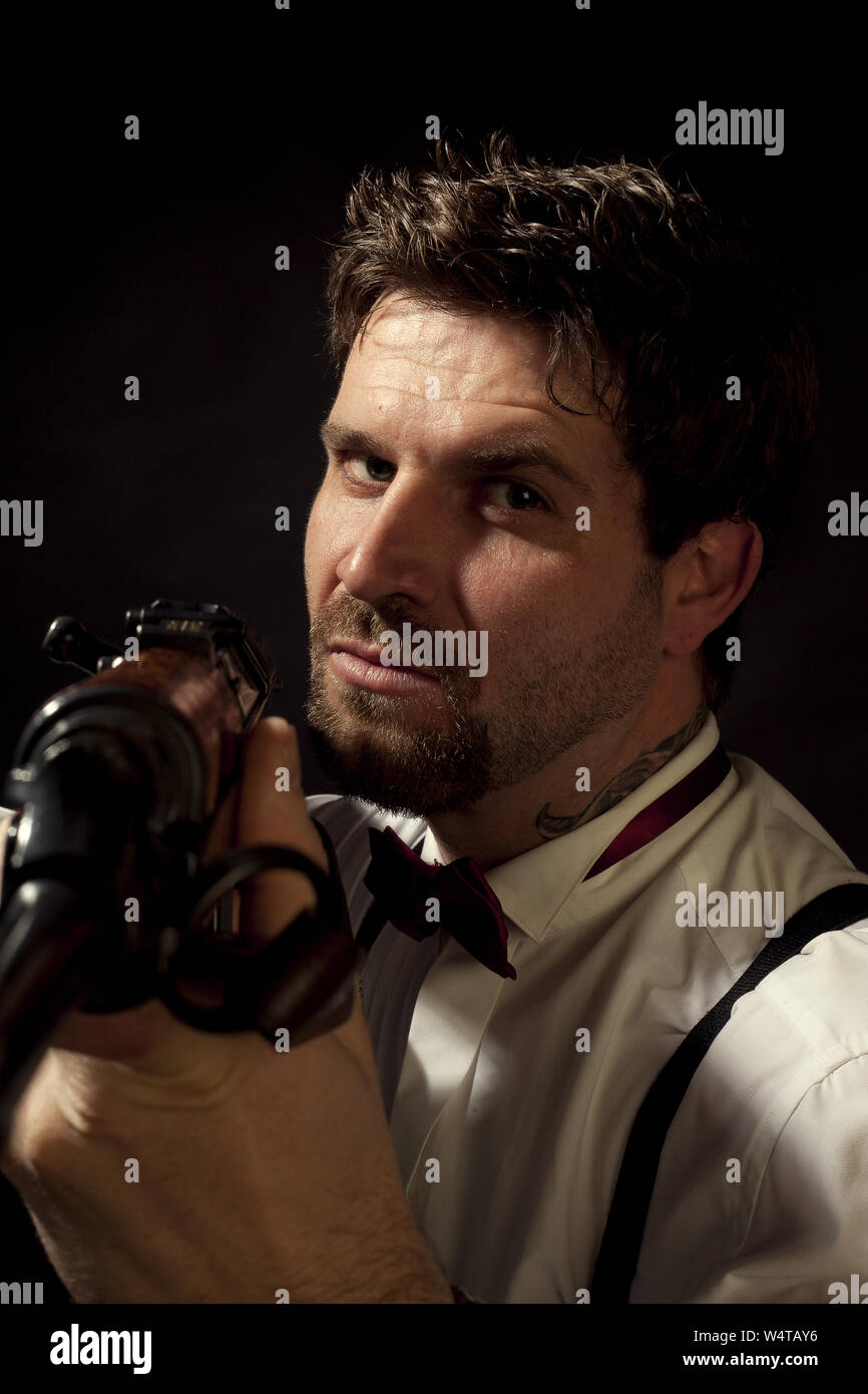 American mafia gangster man in suit with gun pointing a gun at the ...