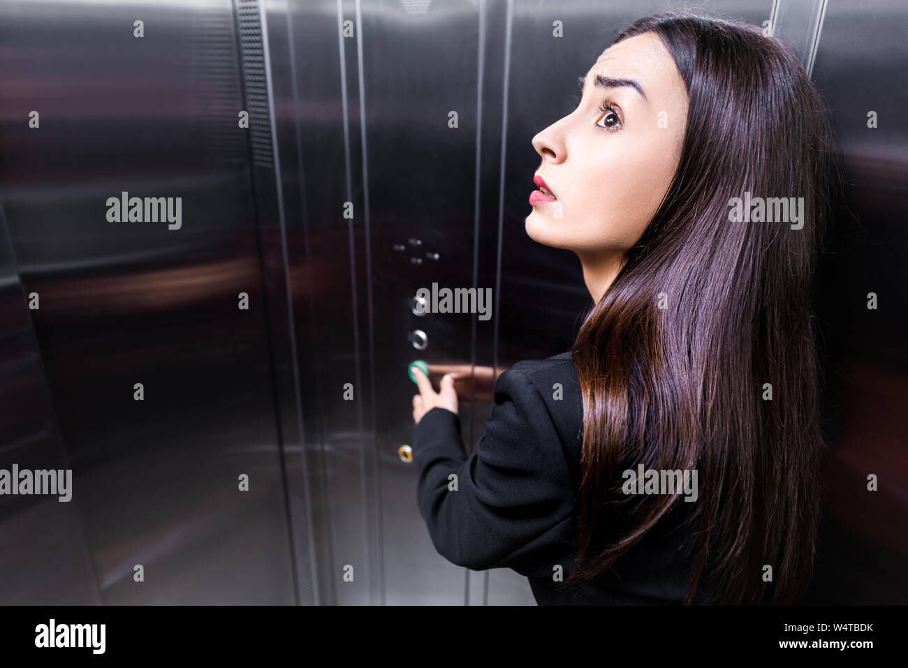 scared businesswoman, suffering from claustrophobia, looking up while ...