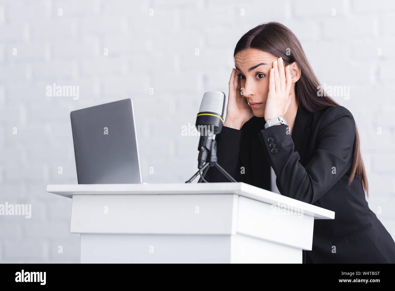 frightened lecturer standing on podium tribune and holding hands near ...