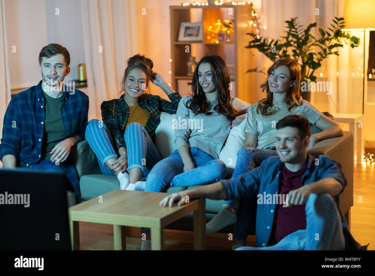 happy friends watching tv at home in evening Stock Photo - Alamy