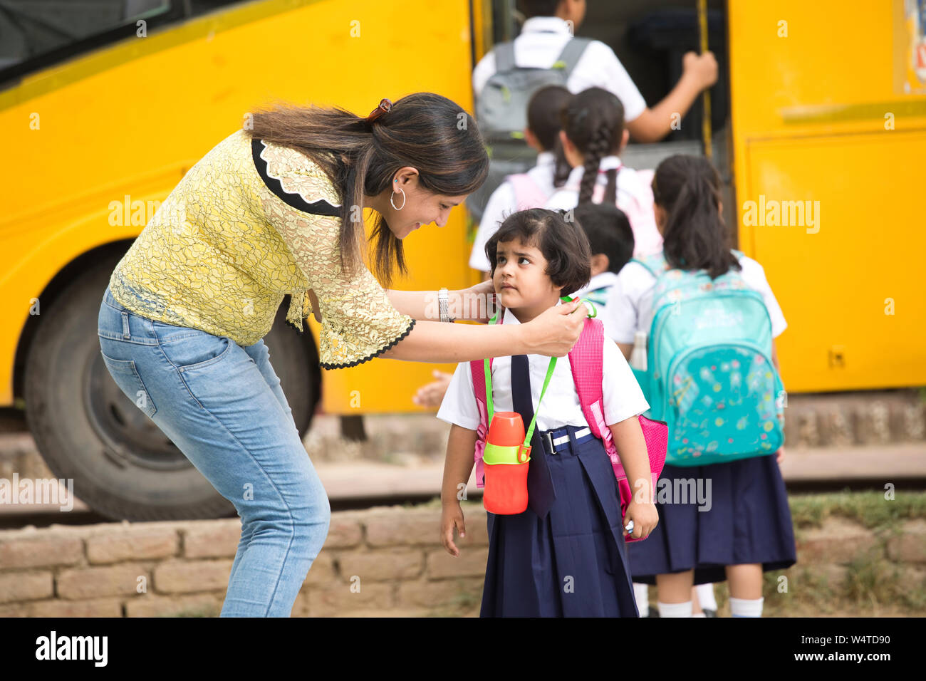 Teacher talking with student before they get on school bus Stock Photo ...