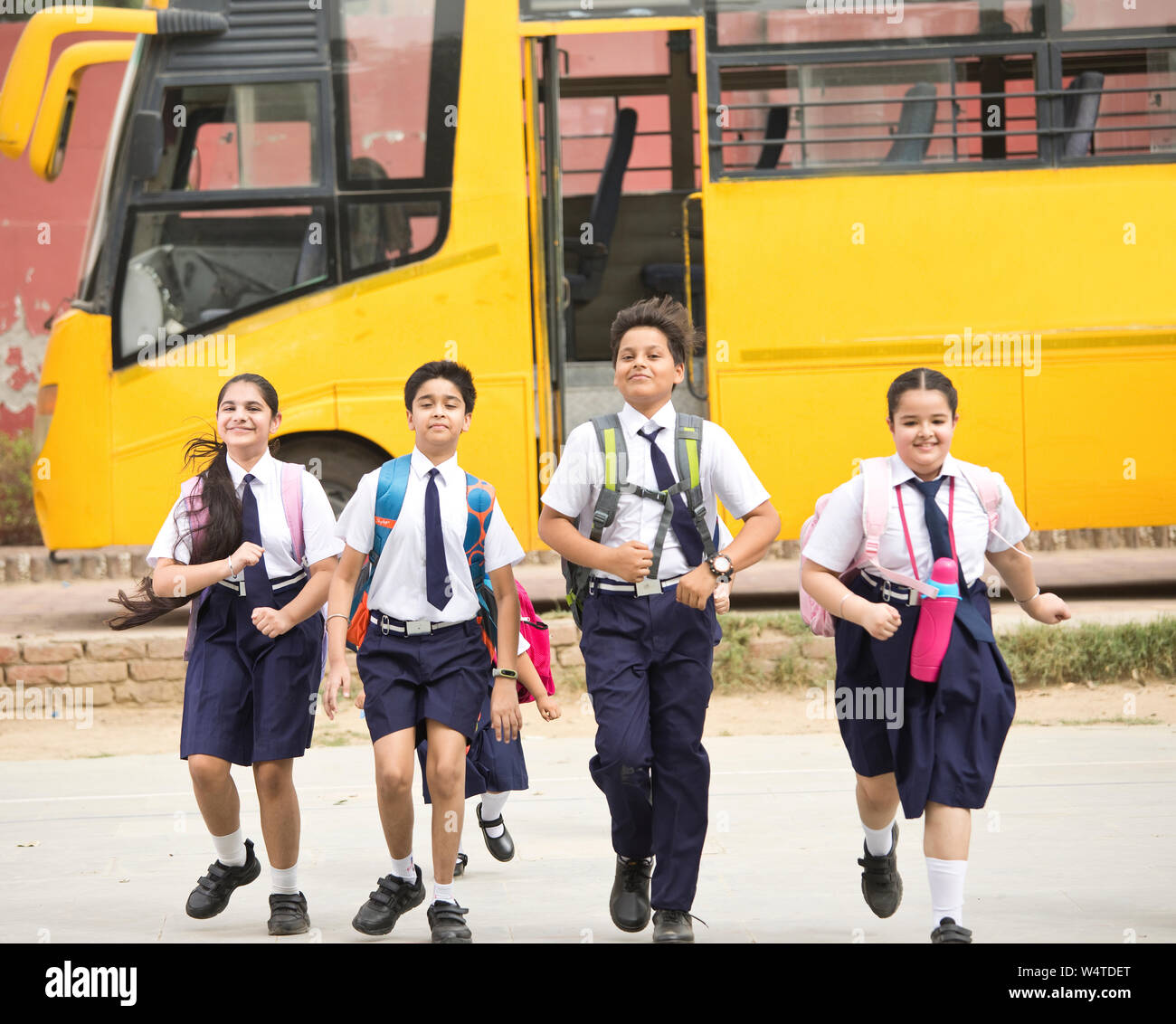 Schoolboys and schoolgirls walking of the school bus Stock Photo - Alamy