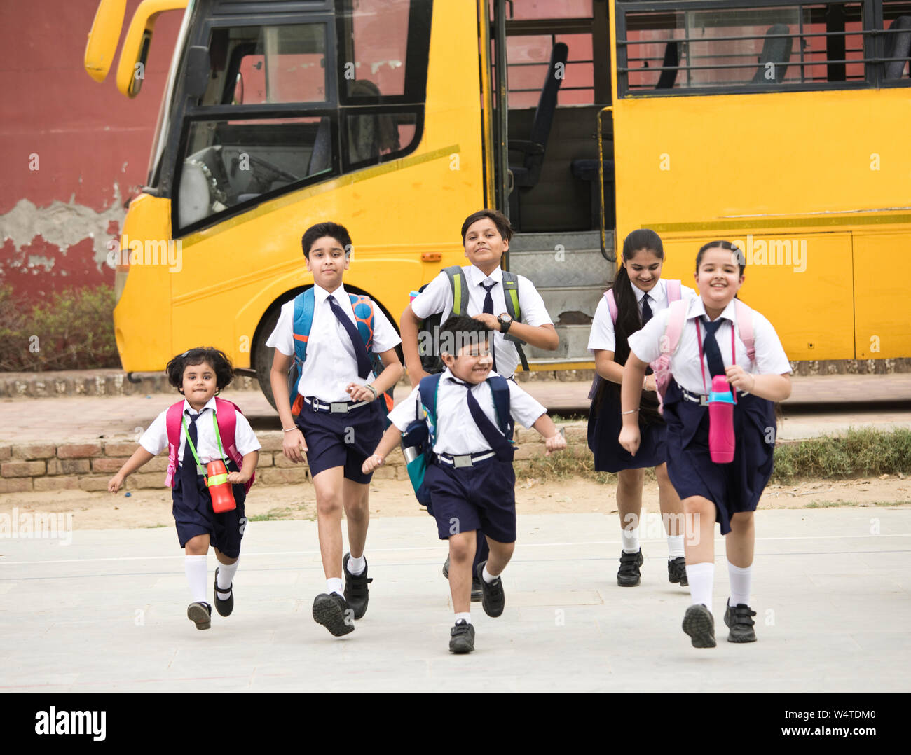 Schoolboys and schoolgirls walking of the school bus Stock Photo - Alamy