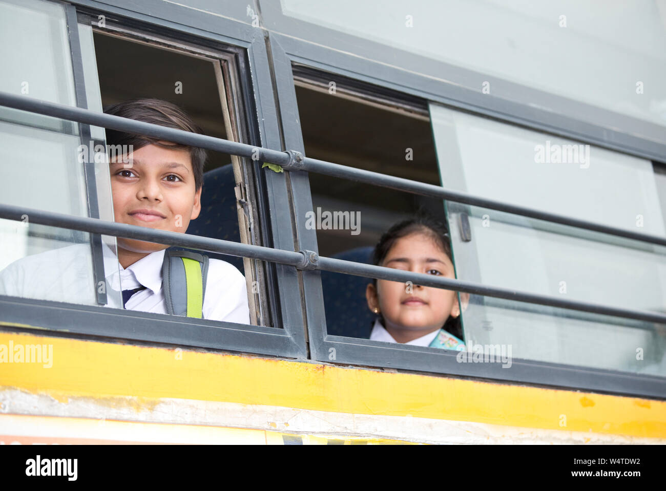 Happy school children looking from window of school bus Stock Photo - Alamy