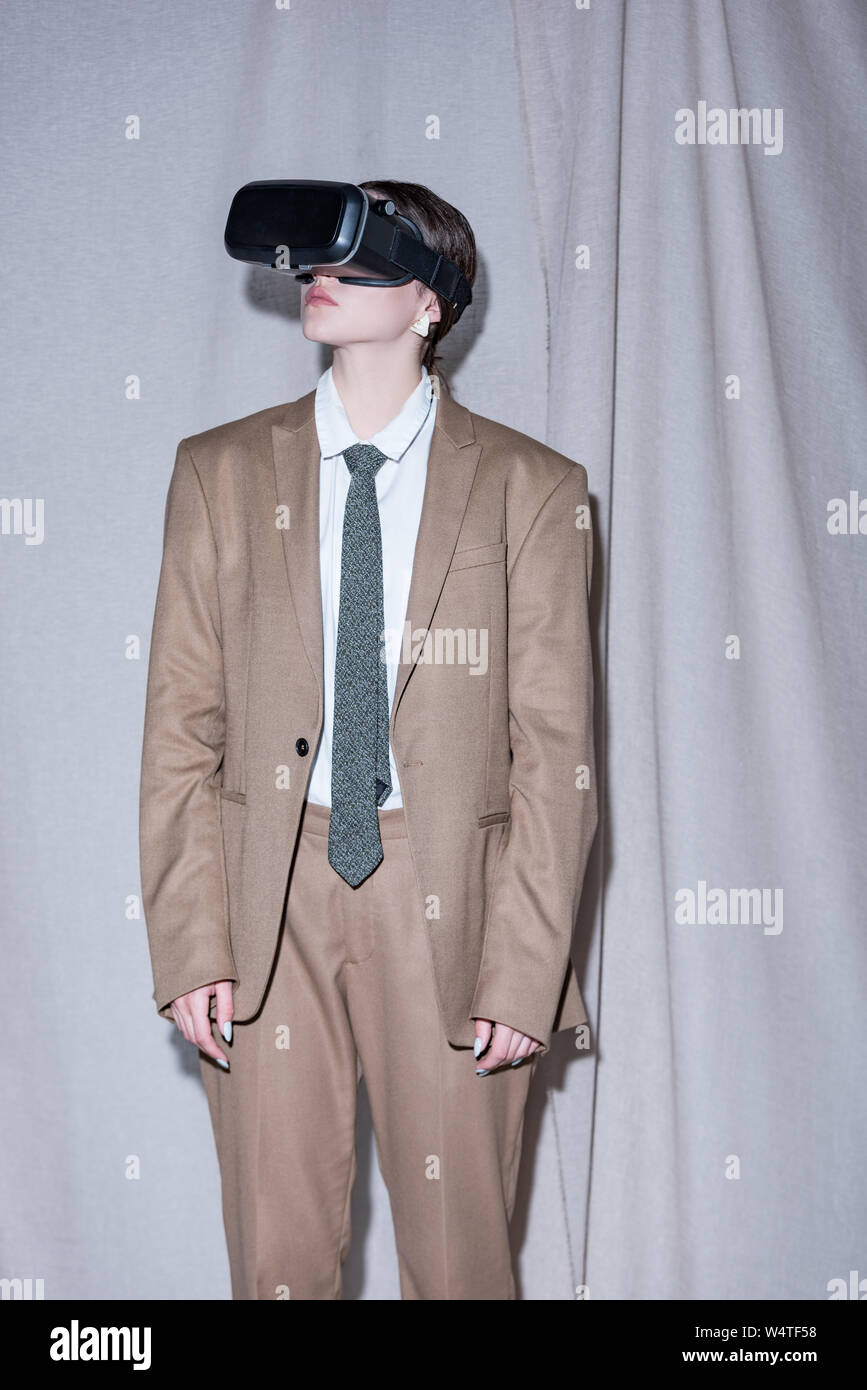 successful woman in vr headset standing on light grey curtain ...
