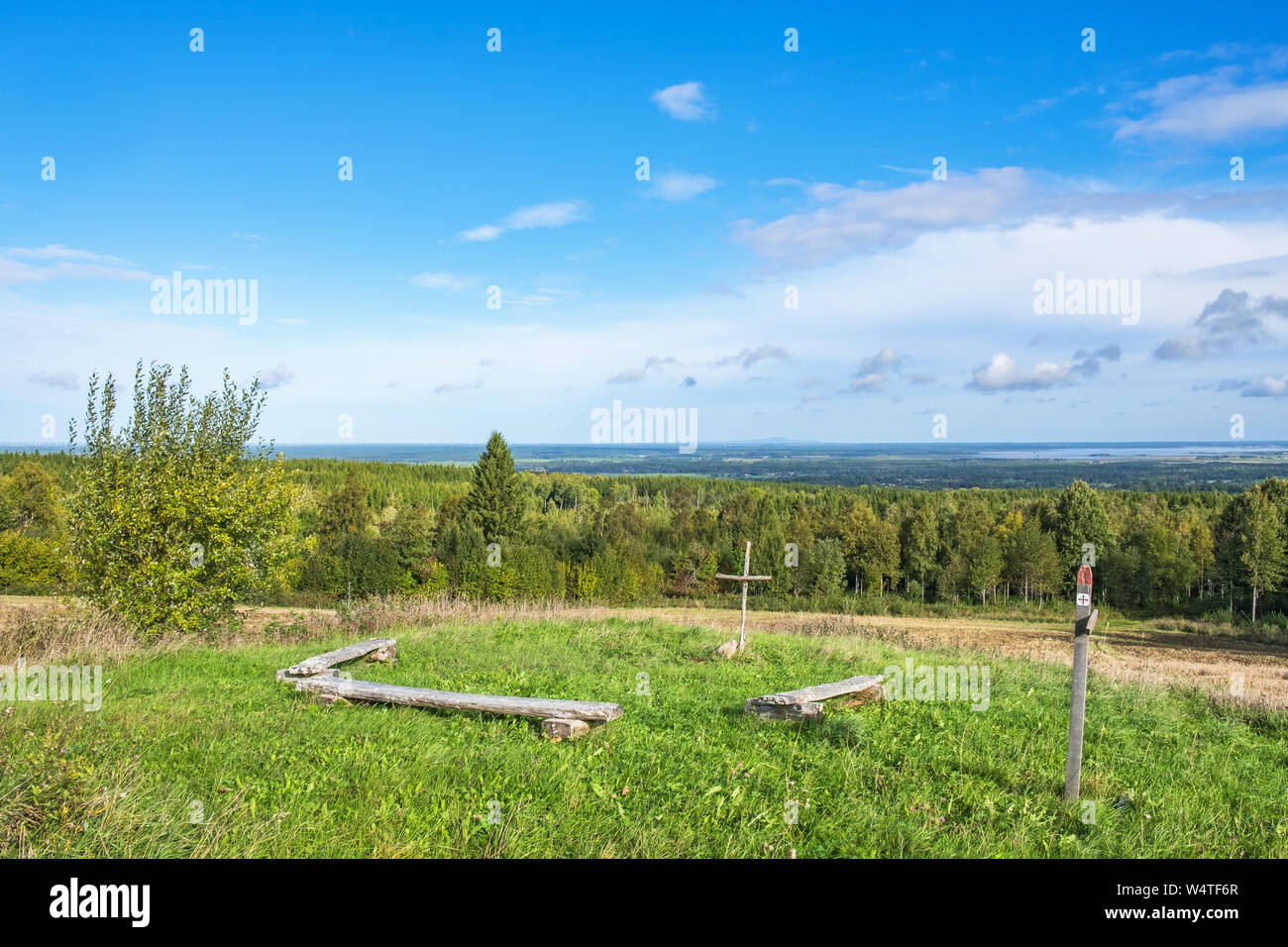 Wooden benches with a cross at a resting place on a footpath with ...