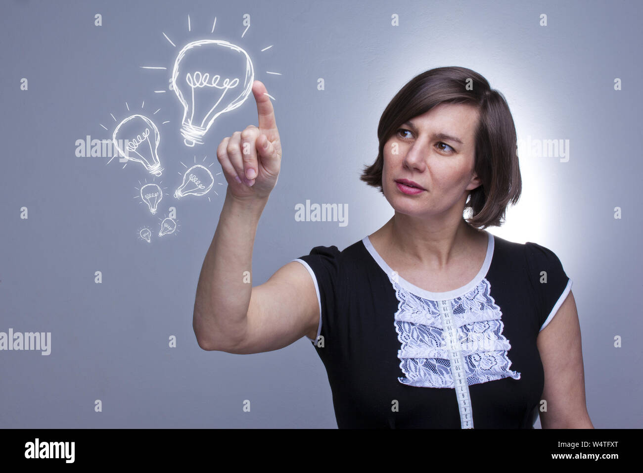 Thinking woman with idea bulb on the blue background Stock Photo - Alamy