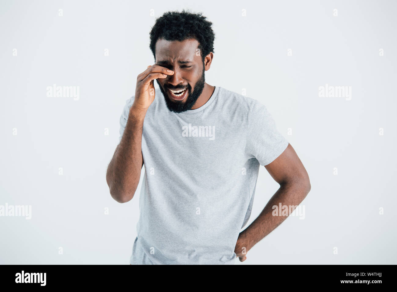upset african american man in grey t-shirt crying isolated on grey ...