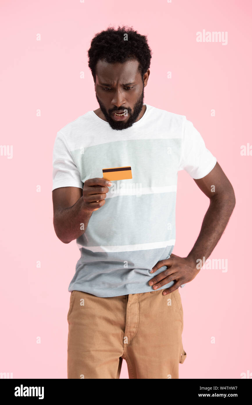 shocked african american man showing credit card isolated on pink Stock ...