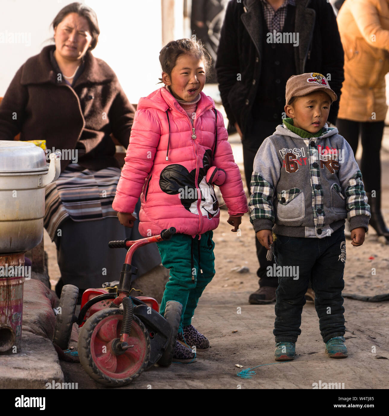China, Tibet, Lhasa, Tibetan children playing on the street by their ...