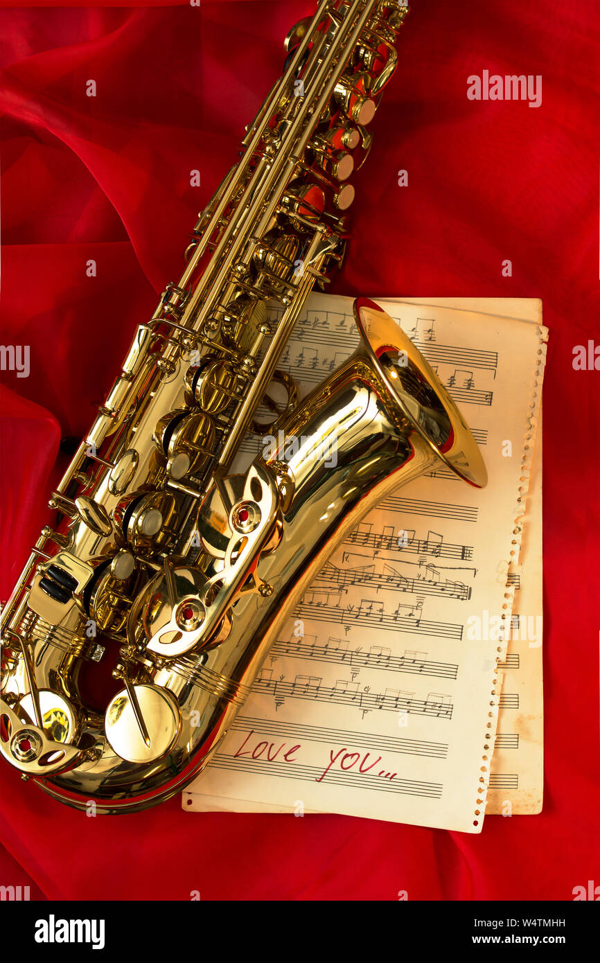 Golden saxophone and music sheets on a red background Stock Photo - Alamy