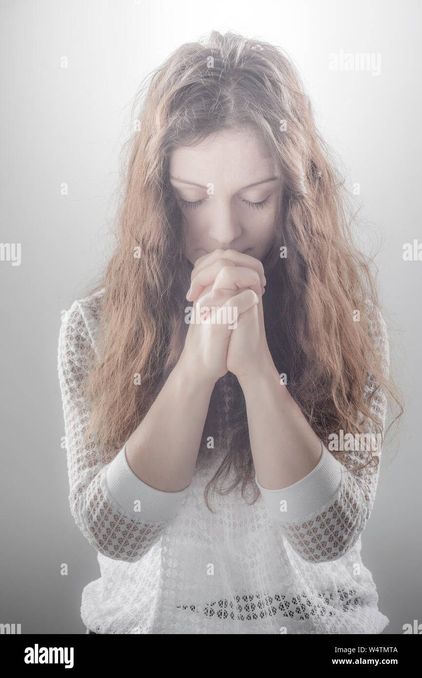 Praying woman on white background with shine Stock Photo - Alamy