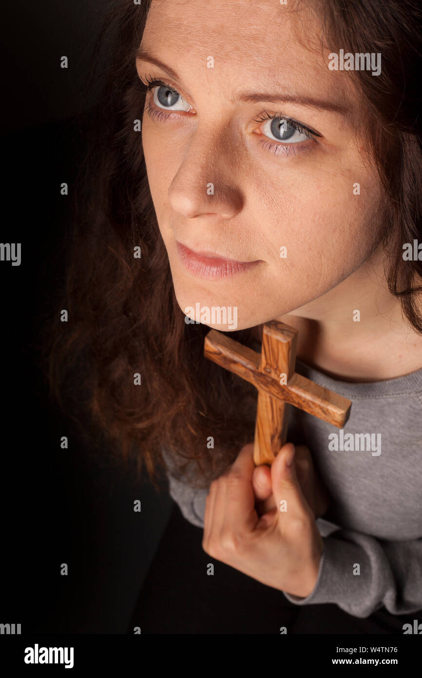 Young christian girl with cross looking up Stock Photo - Alamy