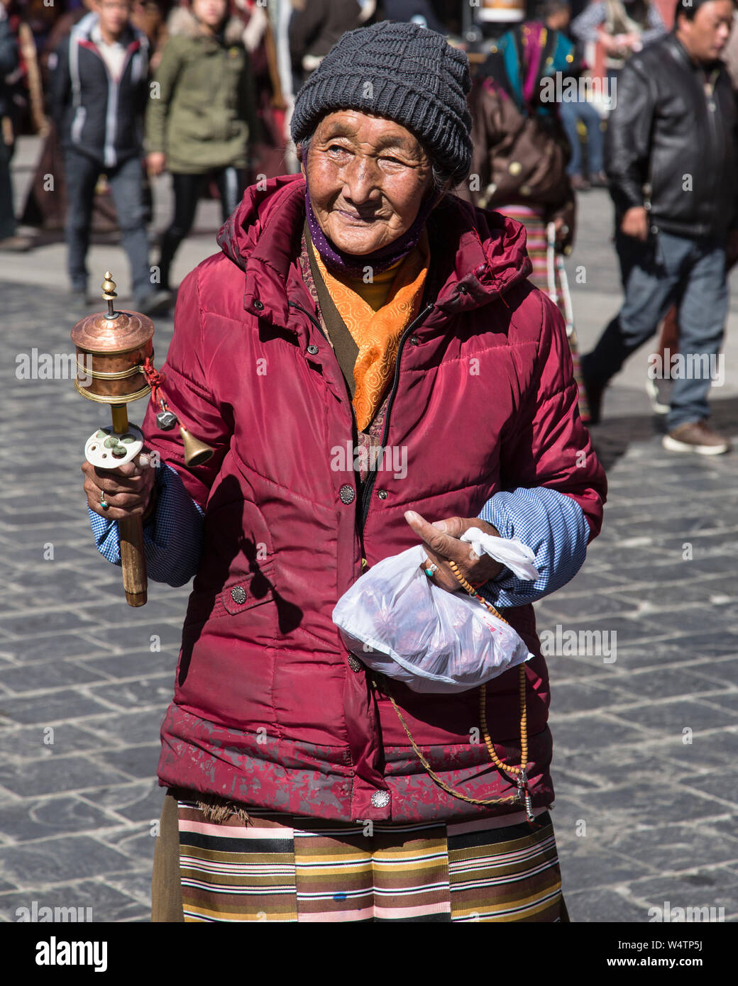 China, Tibet, Lhasa, An older Tibetan woman pilgrim circumambulates the ...