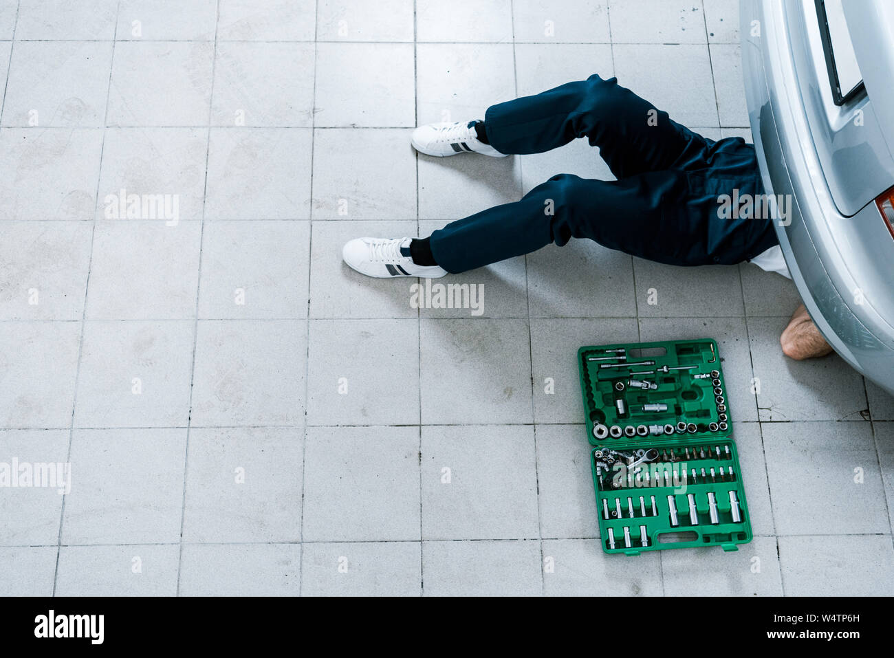 overhead view of car mechanic repairing car in car service Stock Photo ...