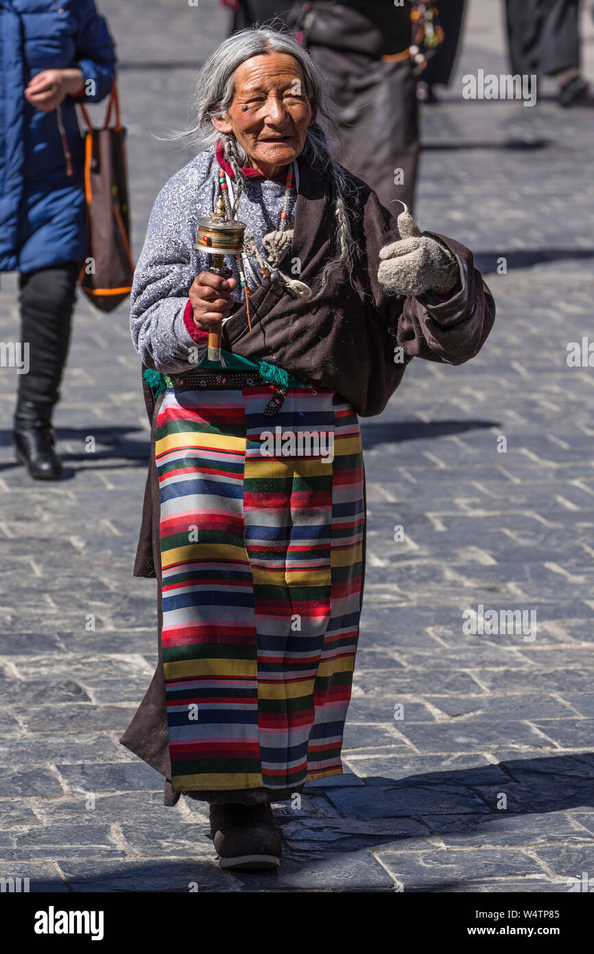 China, Tibet, Lhasa, An older Tibetan woman pilgrim circumambulates the ...