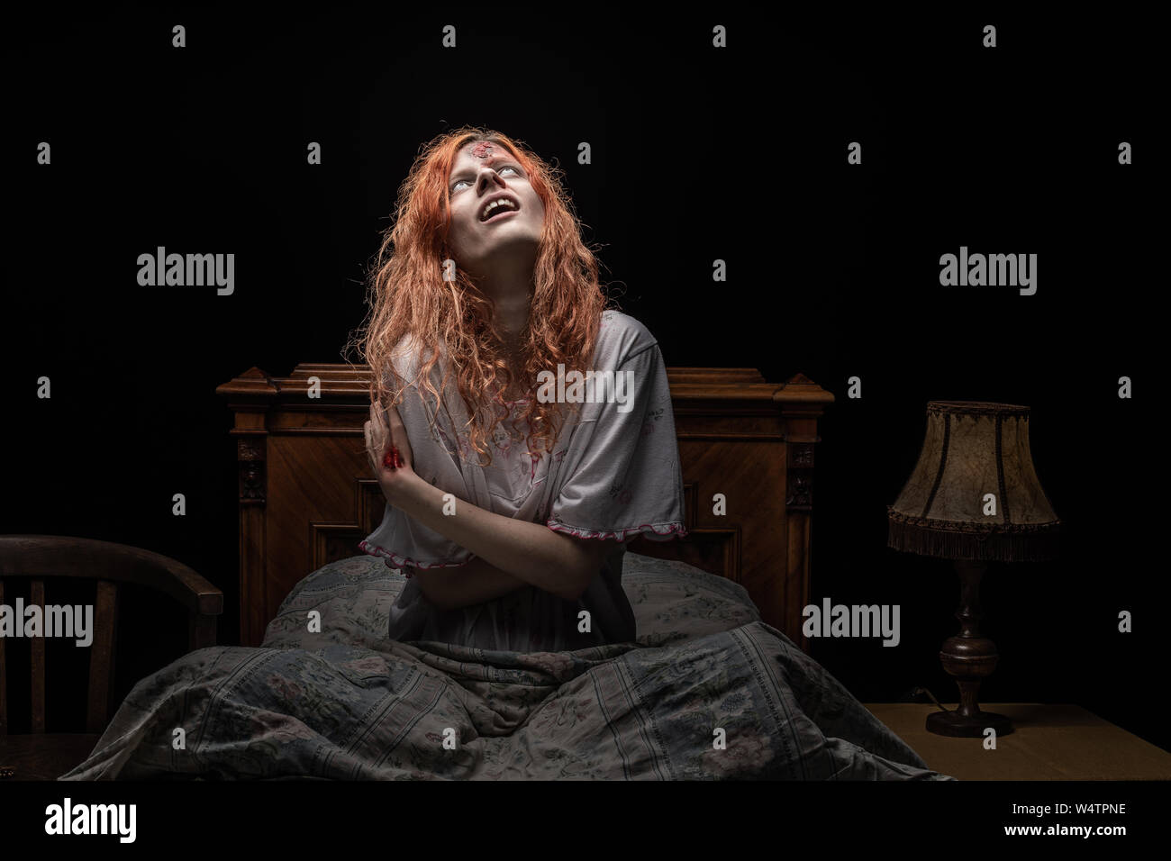 Scary woman possessed by devil in the bed. Exorcism of priest Stock ...