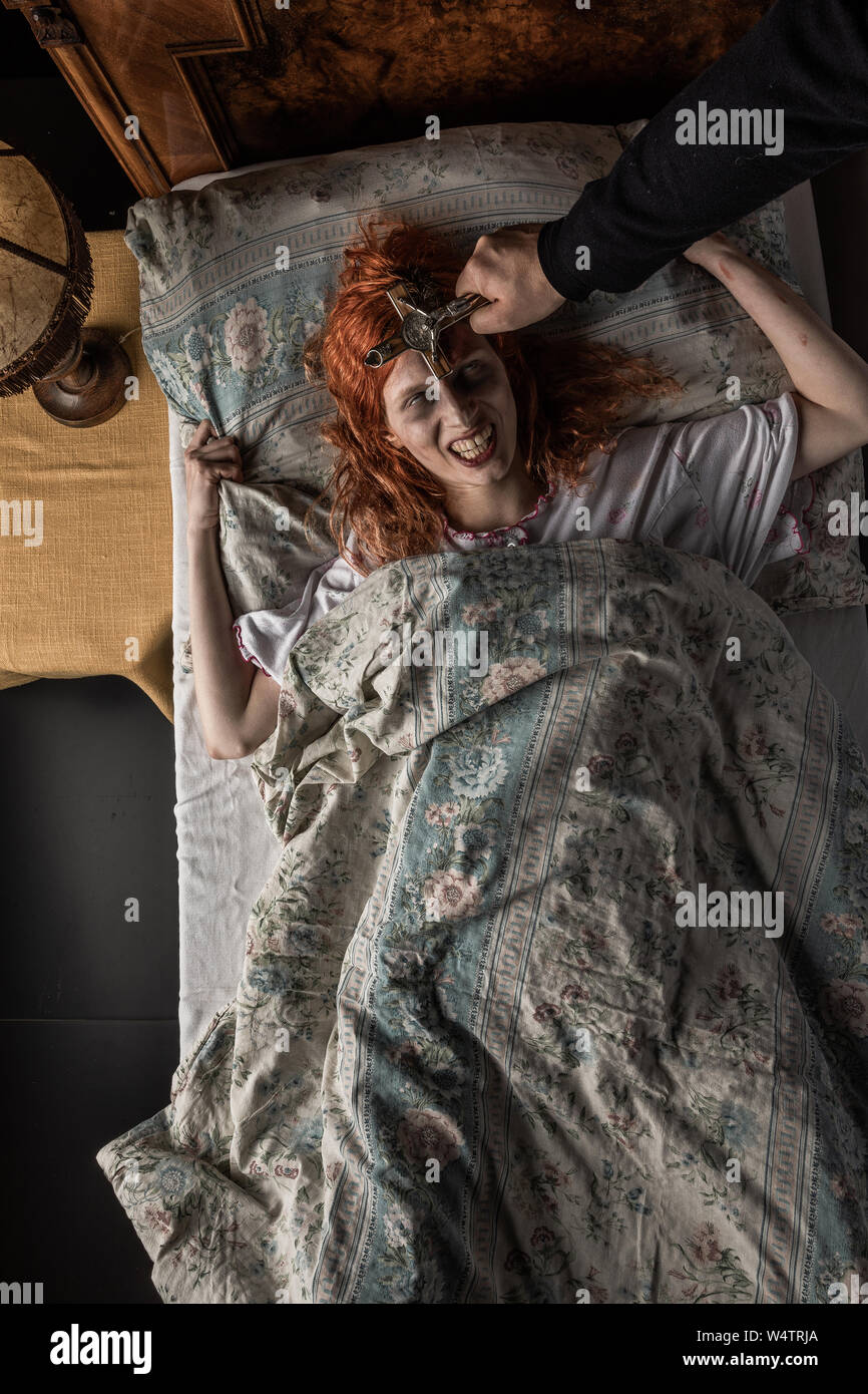 Scary woman possessed by devil in the bed. Exorcism of priest Stock ...