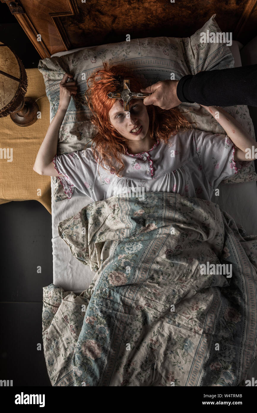 Scary woman possessed by devil in the bed. Exorcism of priest Stock ...