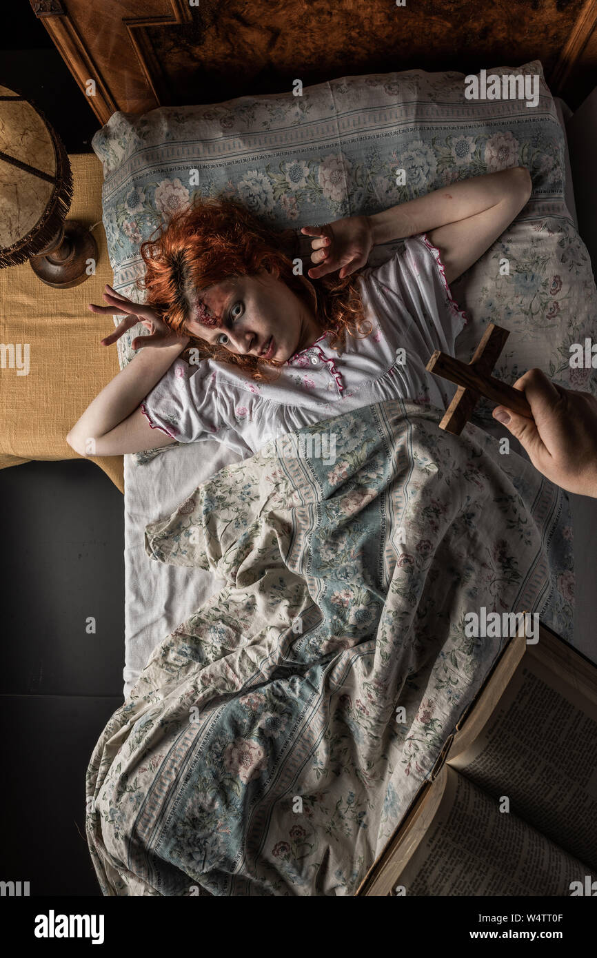 Scary woman possessed by devil in the bed. Exorcism of priest Stock ...