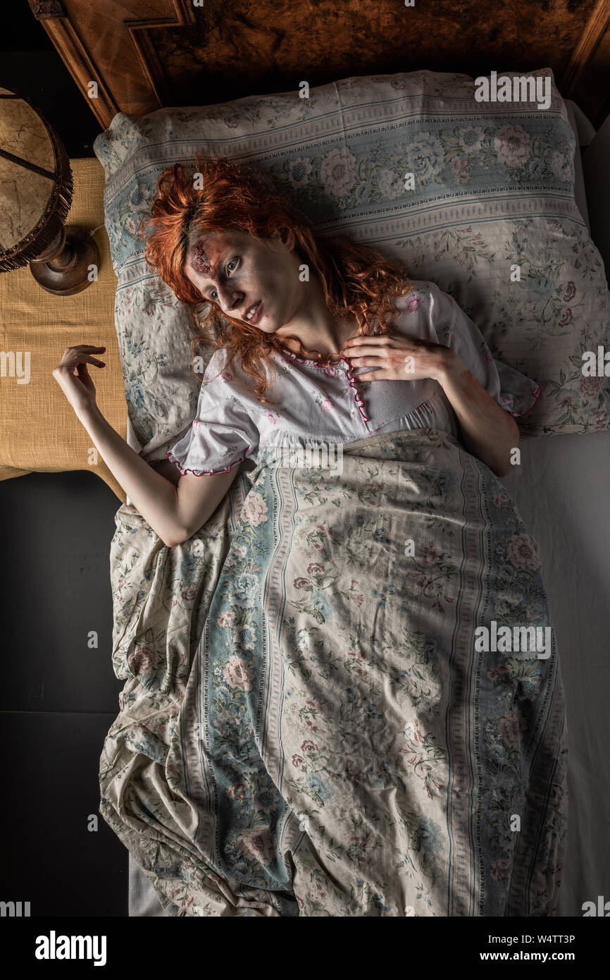 Scary woman possessed by devil in the bed. Exorcism of priest Stock ...