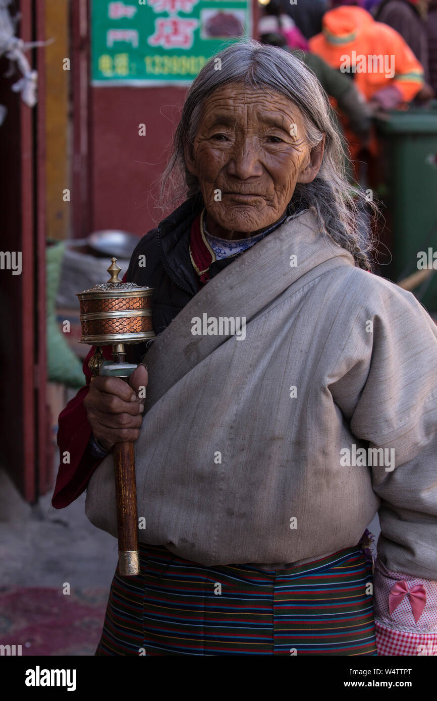 China, Tibet, Lhasa, An older Tibetan woman pilgrim circumambulates the ...