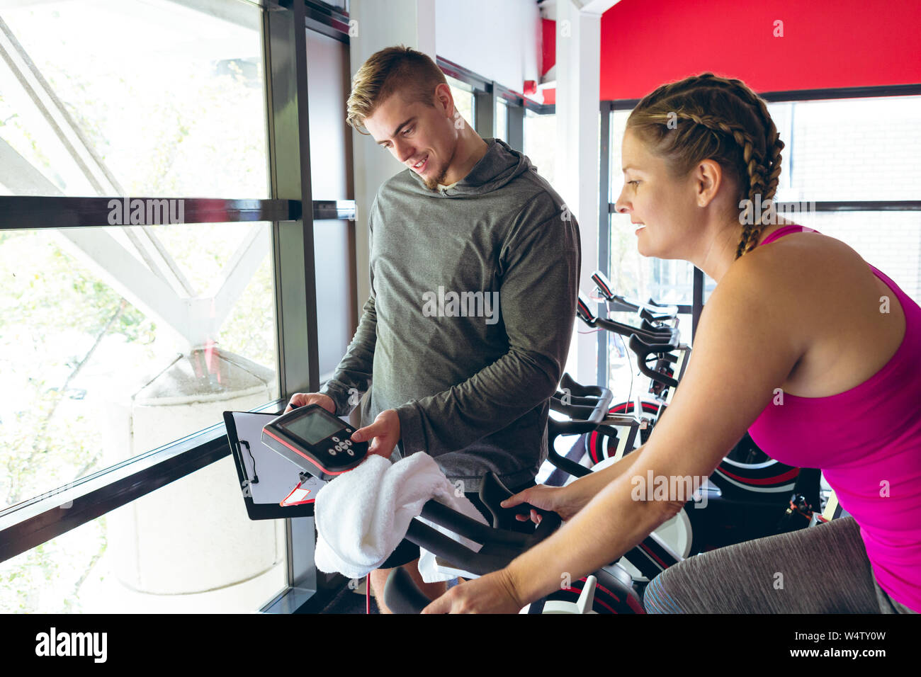 Trainer assisting female athlete with exercise in fitness studio Stock ...