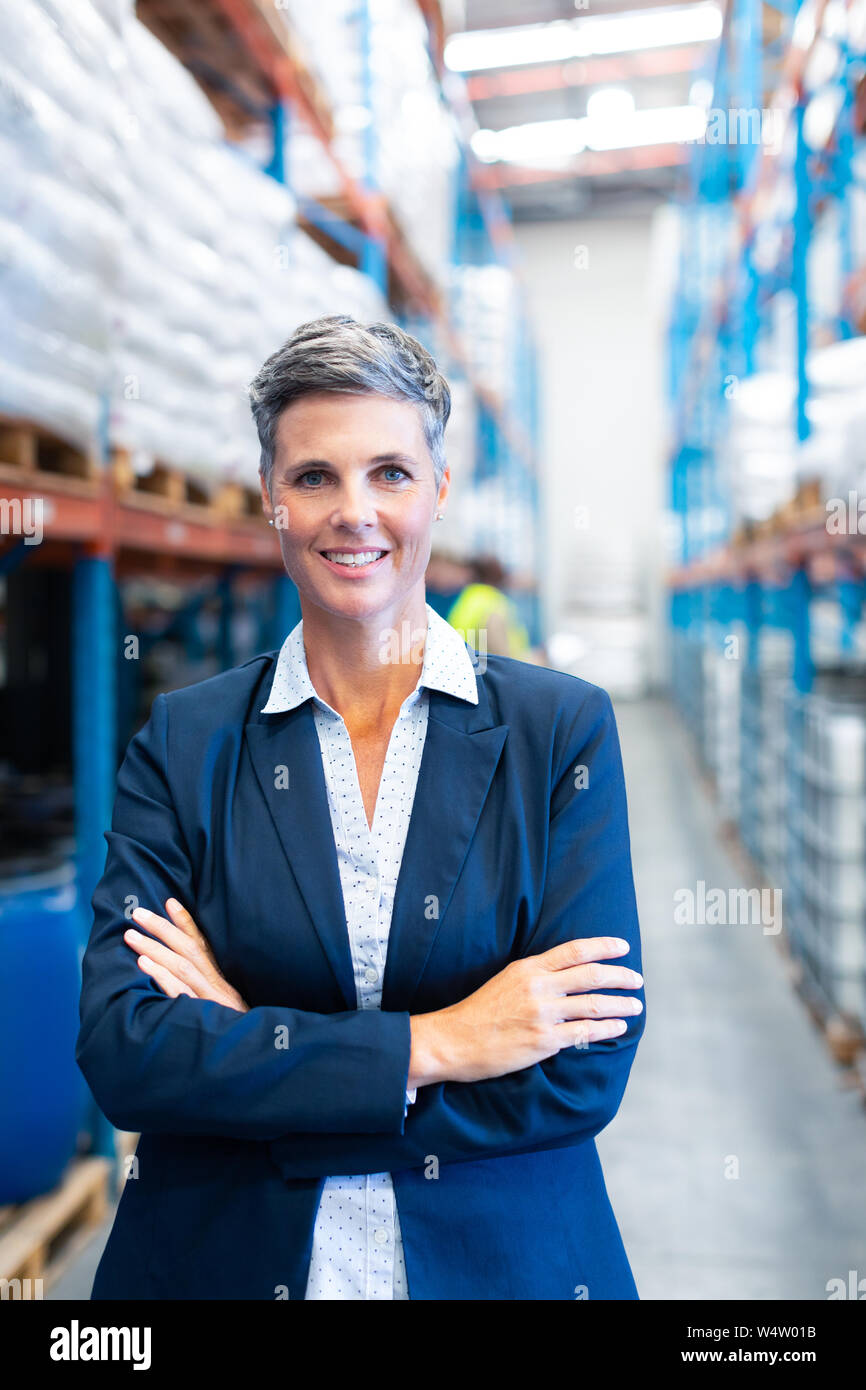 Female manager standing with arm crossed and looking at camera in ...