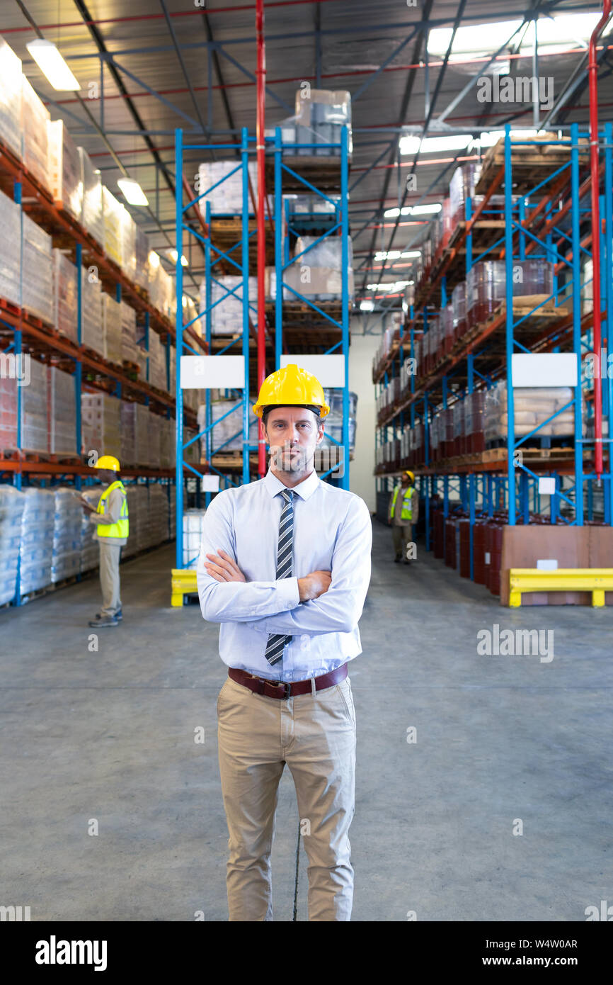 Male supervisor standing with arms crossed and looking at camera in ...