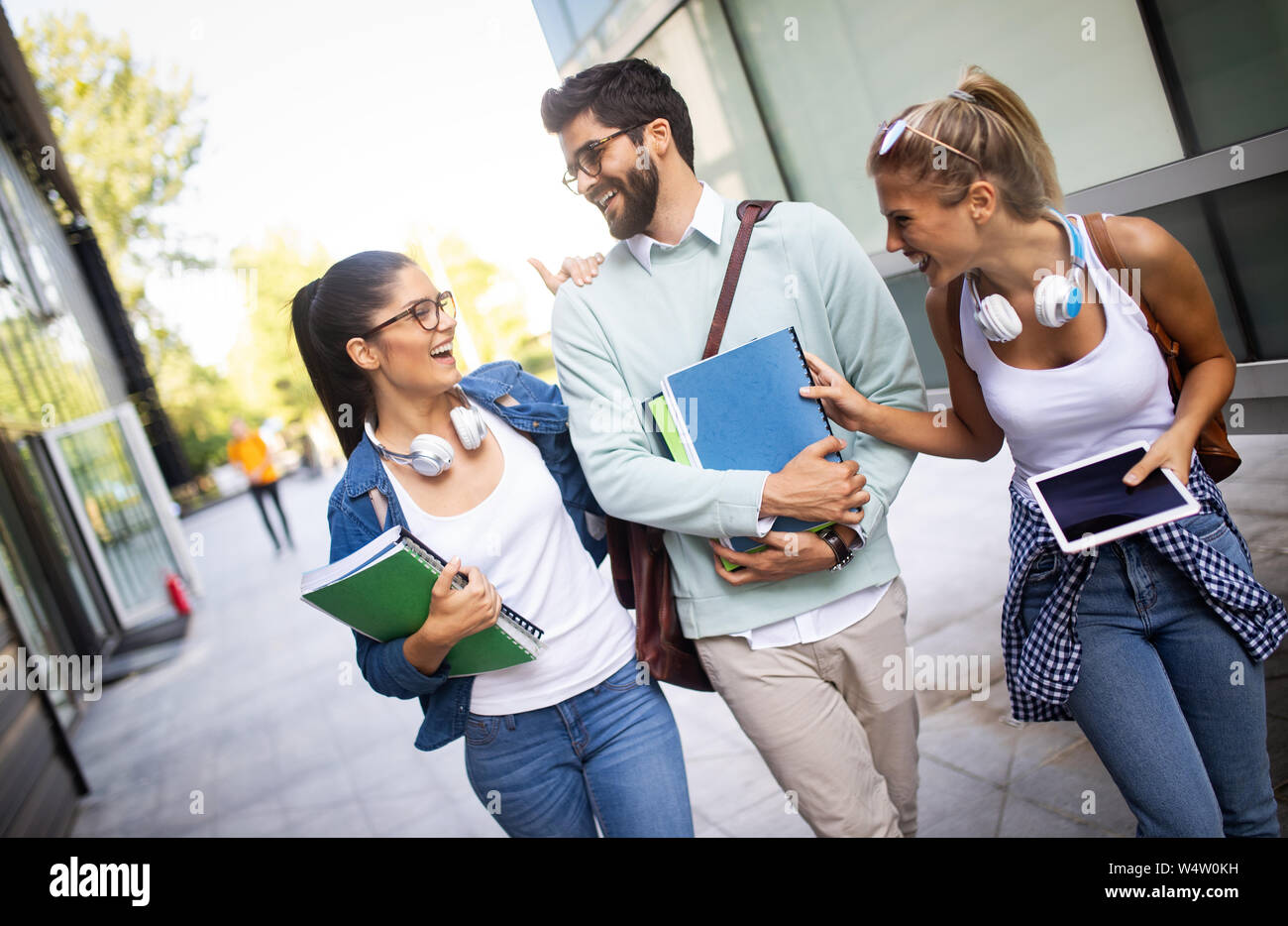 Happy young university students friends studying with books at ...