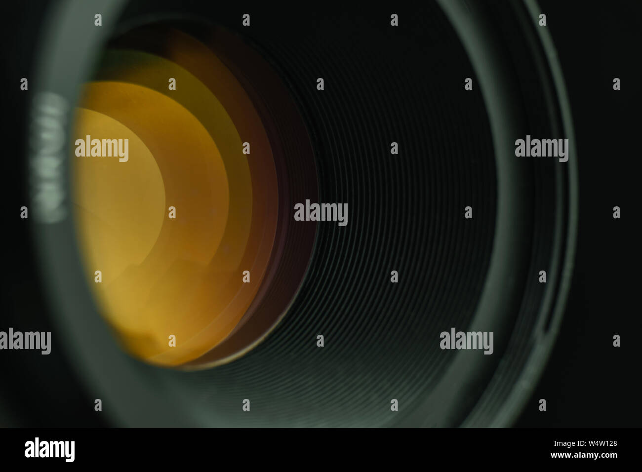 Beautiful camera lens with yellow light of glass on a black background ...