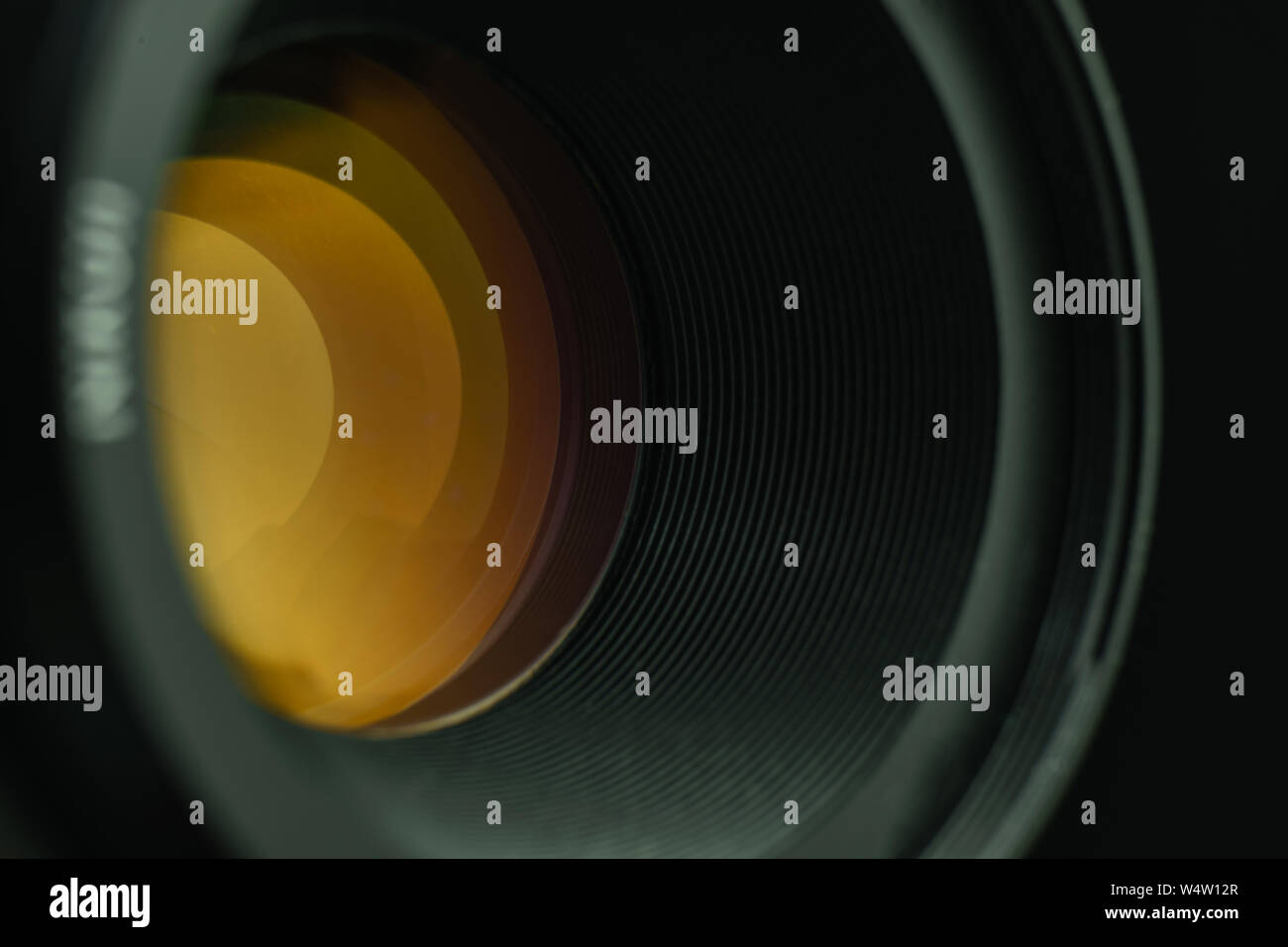 Beautiful camera lens with yellow light of glass on a black background ...