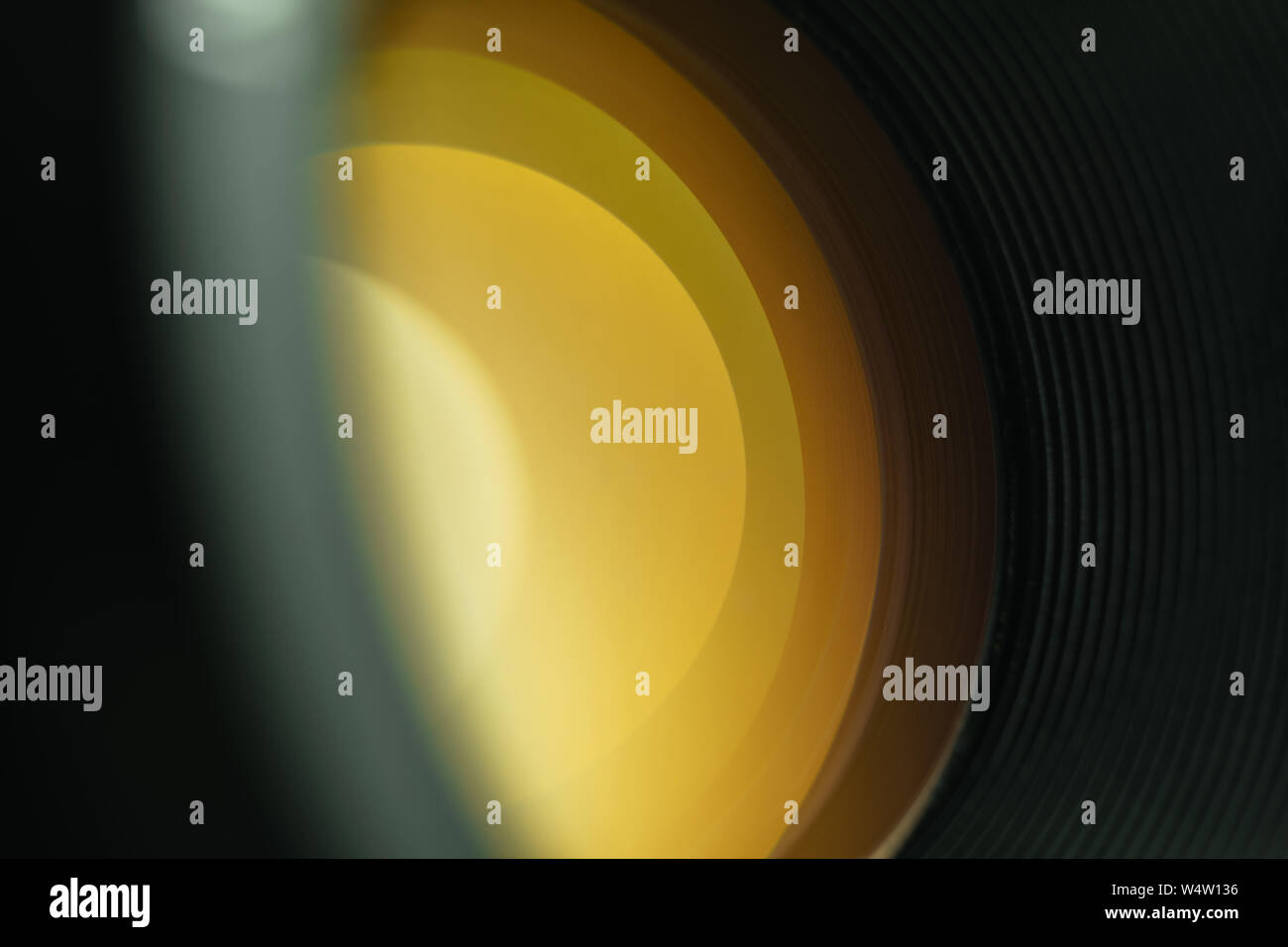 Beautiful camera lens with yellow light of glass on a black background ...