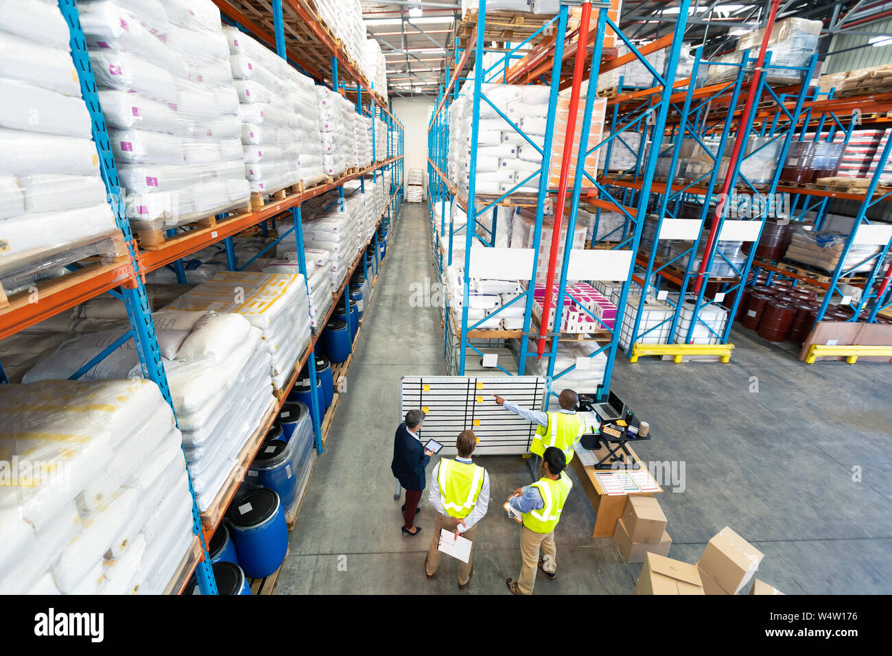 Warehouse staff discussing over whiteboard in warehouse Stock Photo - Alamy