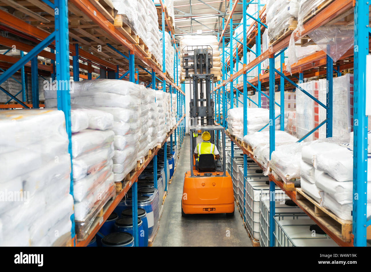 Male worker driving forklift in warehouse Stock Photo - Alamy