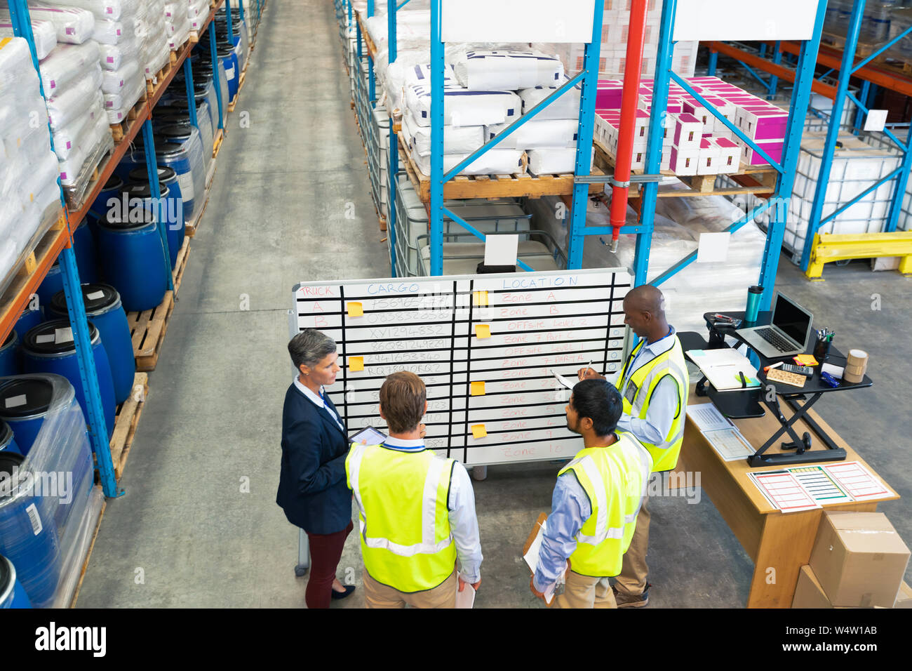 Warehouse staff discussing over whiteboard in warehouse Stock Photo - Alamy